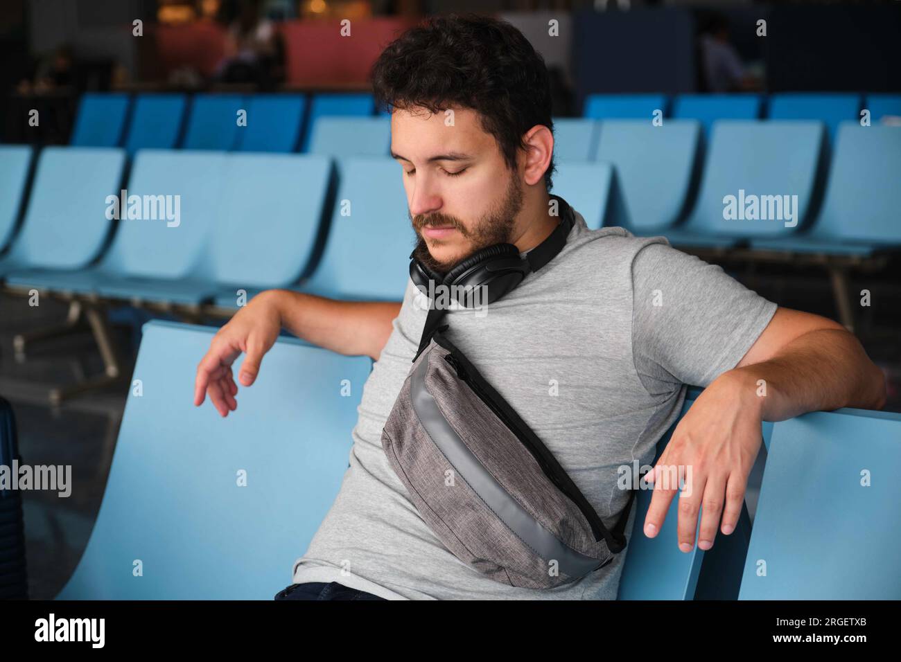 Man trying to sleep at the airport, sad because his flight was delayed ...