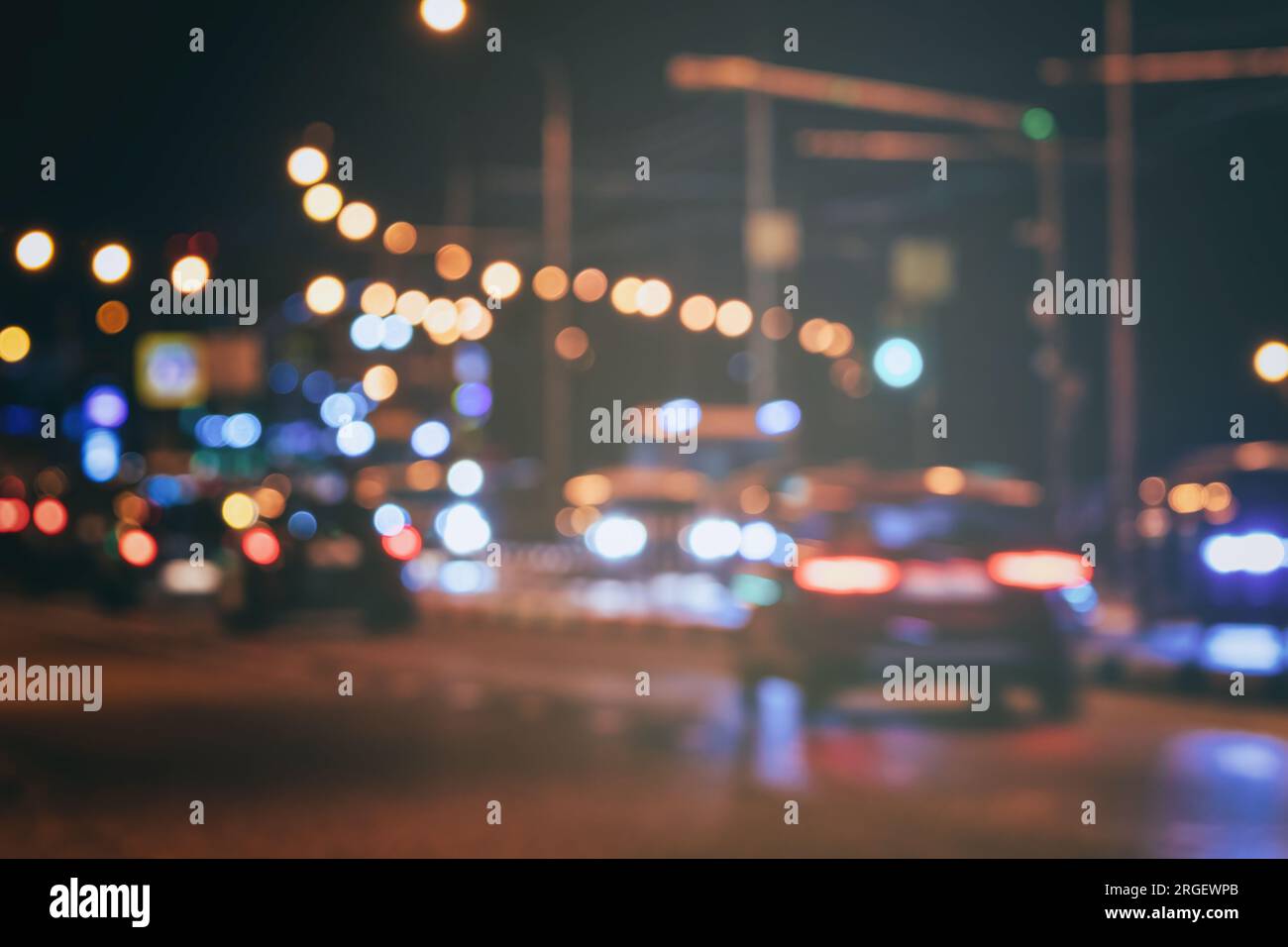 Blurry lights of moving cars and lanterns reflecting on the wet asphalt ...