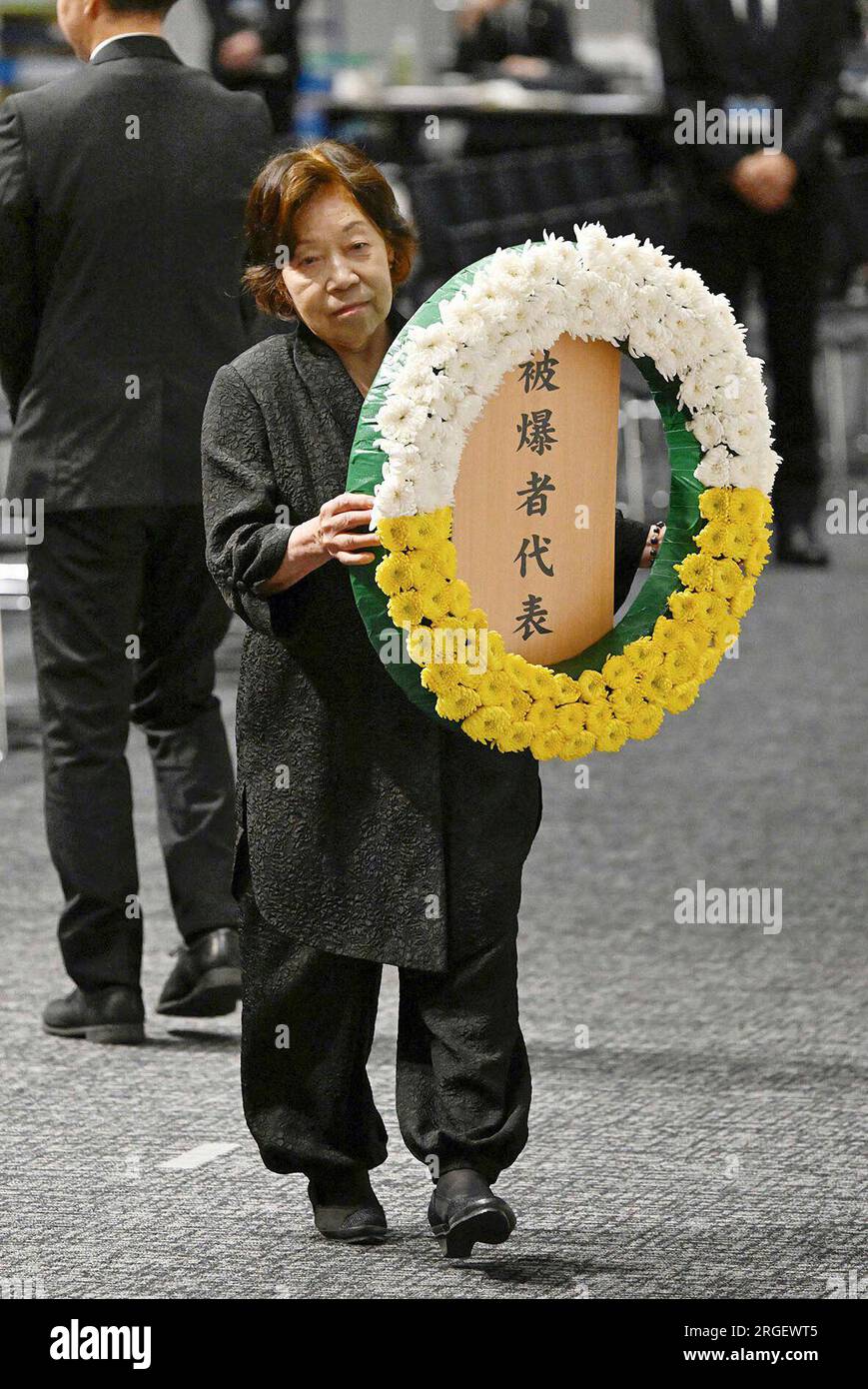 Takeko Kudo, representing atomic bomb victims, walks over to lay a ...