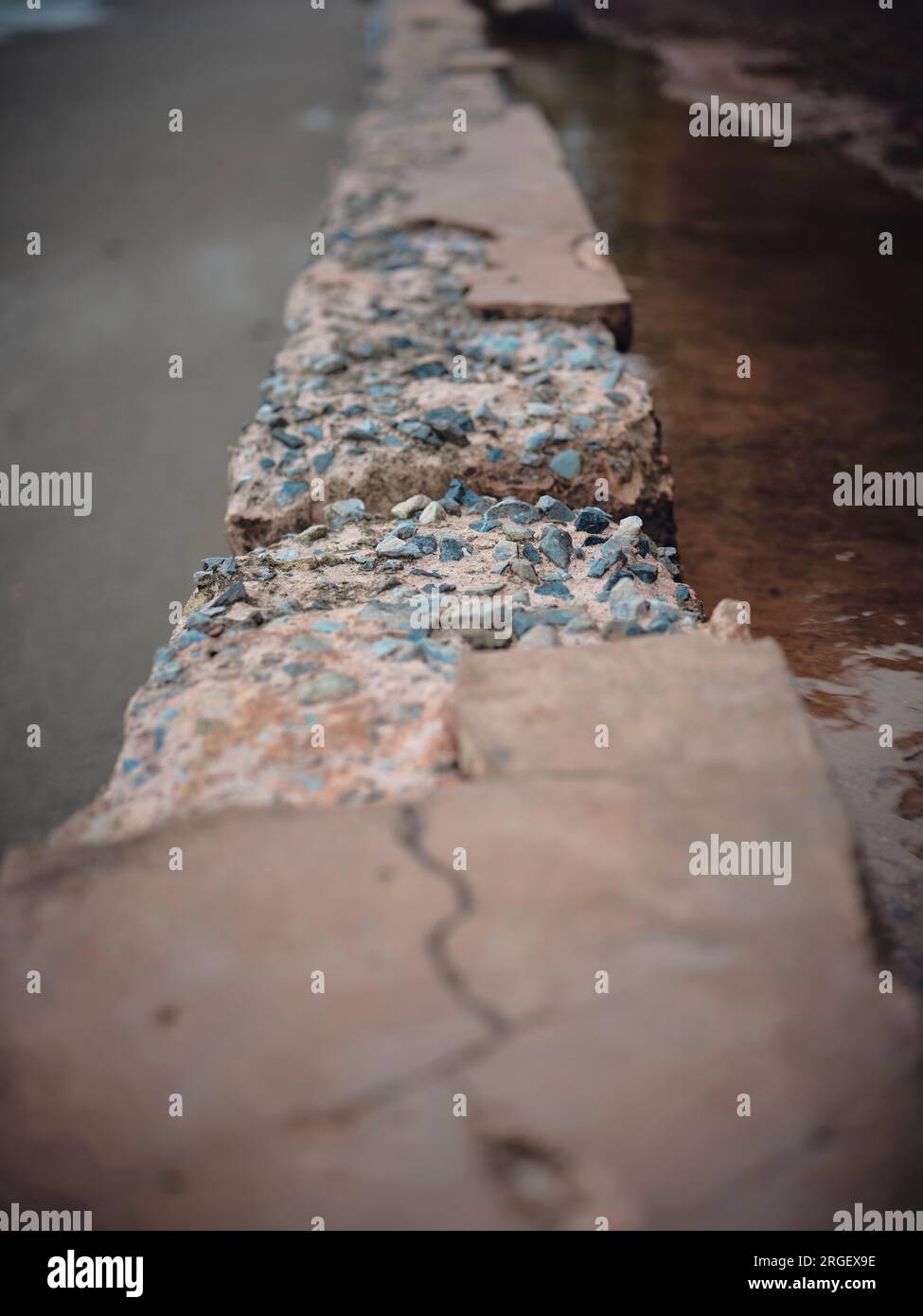 Broken sidewalk curb with exposed rebar and jagged edges Stock Photo ...