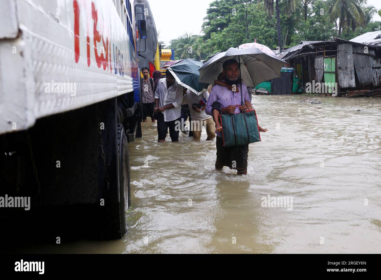 Chattogram. 9th Aug, 2023. Pedestrians wade through a flooded street in ...