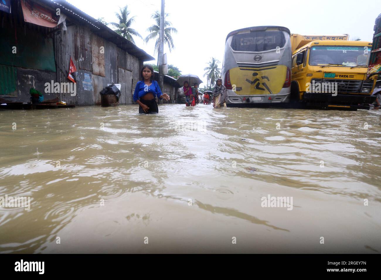 Chattogram. 9th Aug, 2023. Pedestrians wade through a flooded street in ...