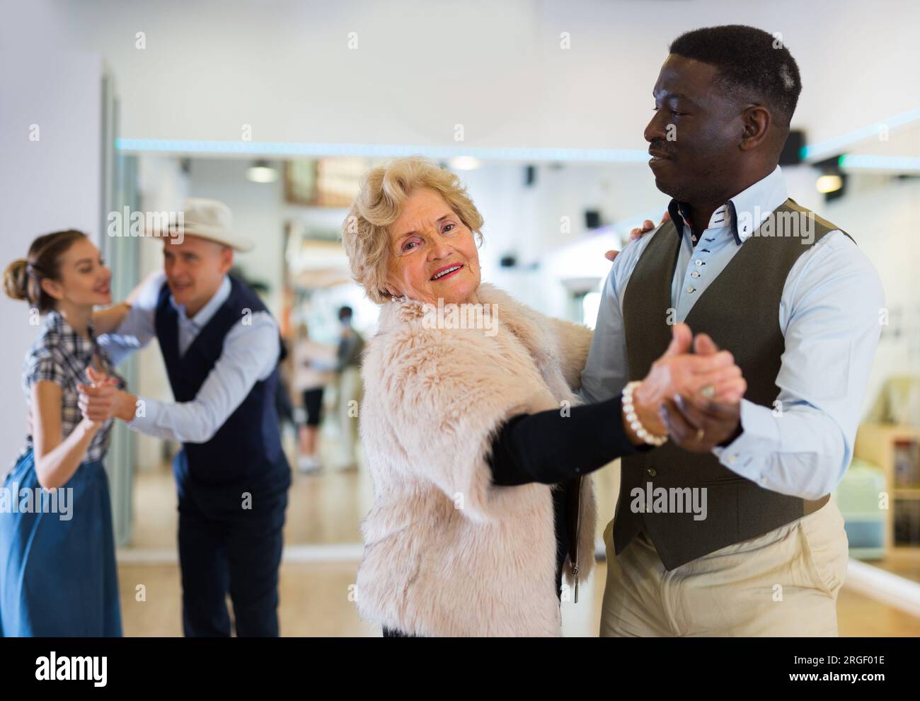 Elderly woman learning ballroom dancing in pair in dance studio Stock ...