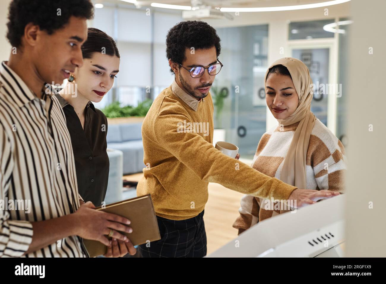 Waist up portrait group of young Arabian professionals using digital ...