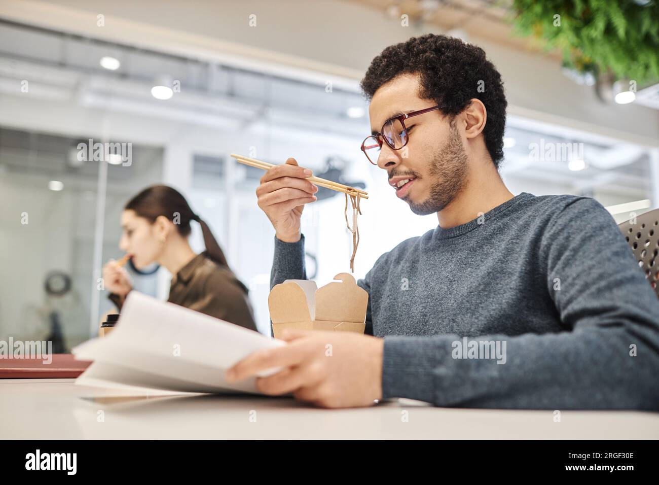 Side view portrait of young Middle Eastern man eating takeout food at ...