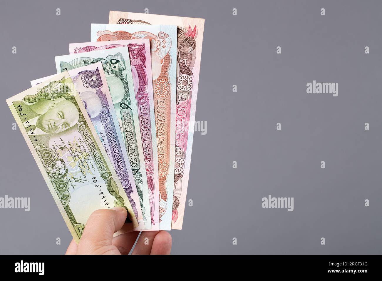 Afghan money - afghani in the hand on a gray background Stock Photo - Alamy