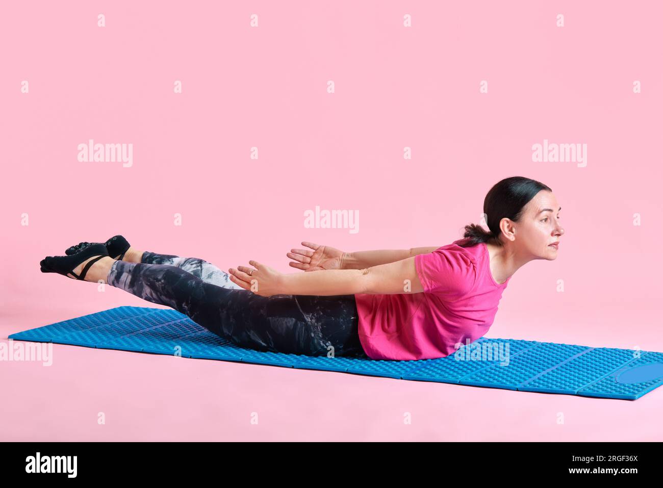 Strong back exercises. Mature woman lying on fitness matt and training ...