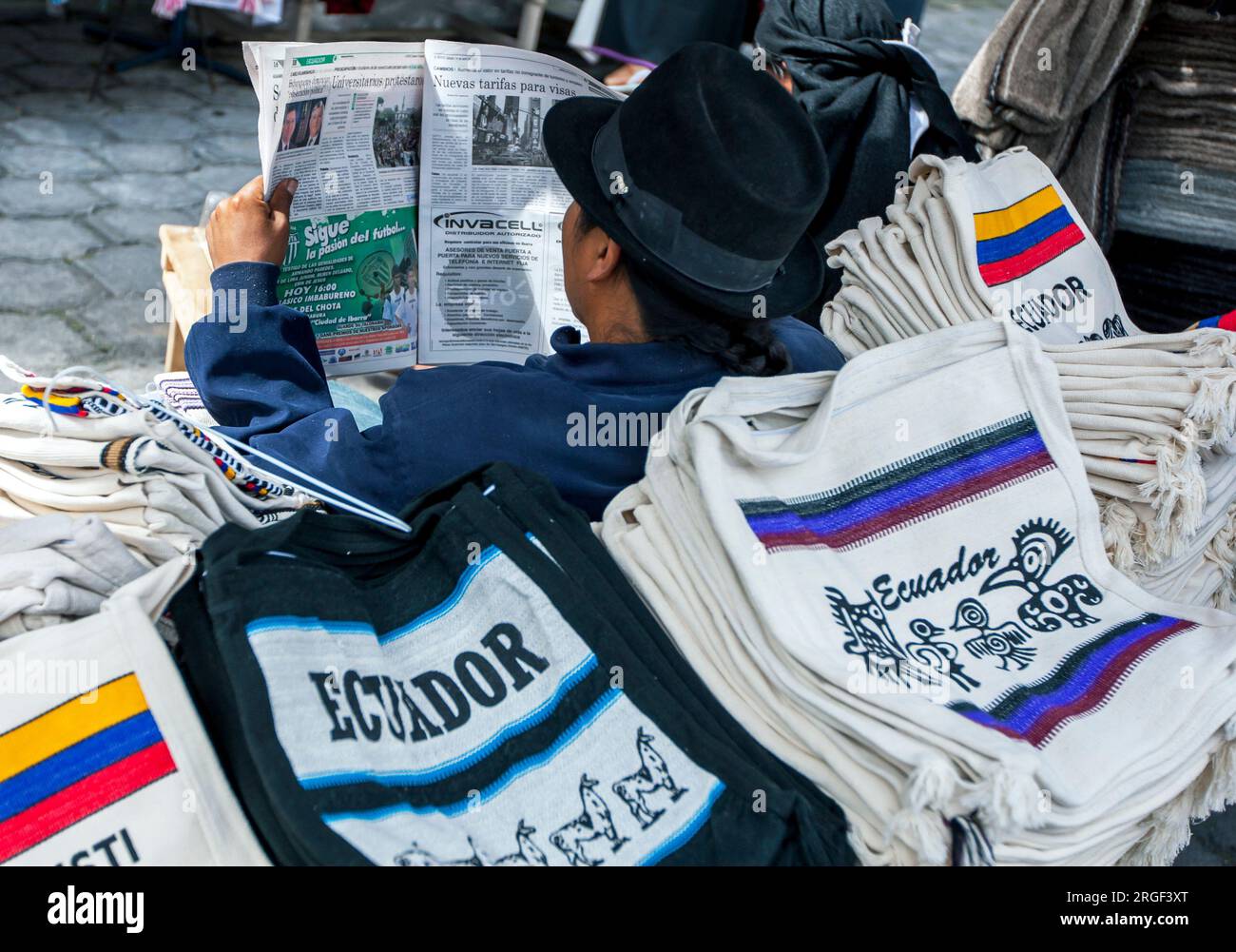 A textile salesman sitting in a chair reads the newspaper at the Indian ...