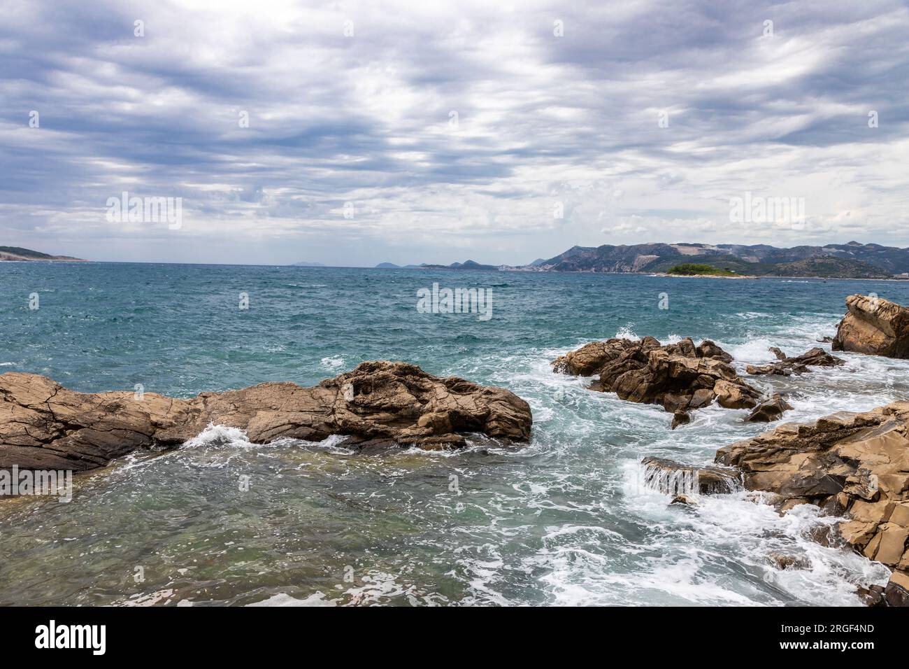 The rough coast line full with big rocks of the small fishing village ...