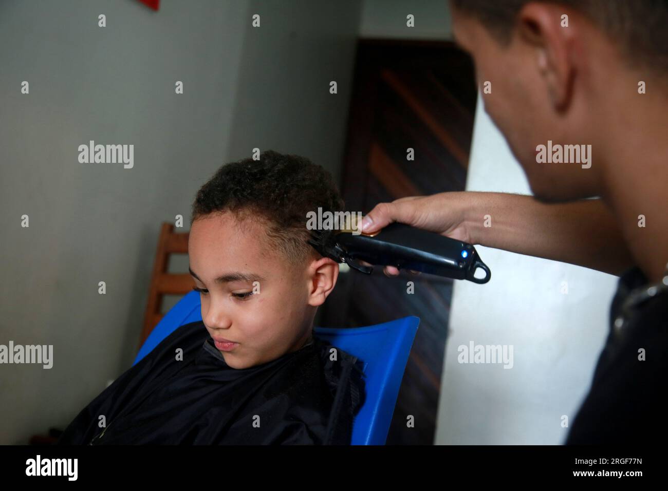 salvador, bahia, brazil - august 27, 2022: barber uses a machine to cut ...