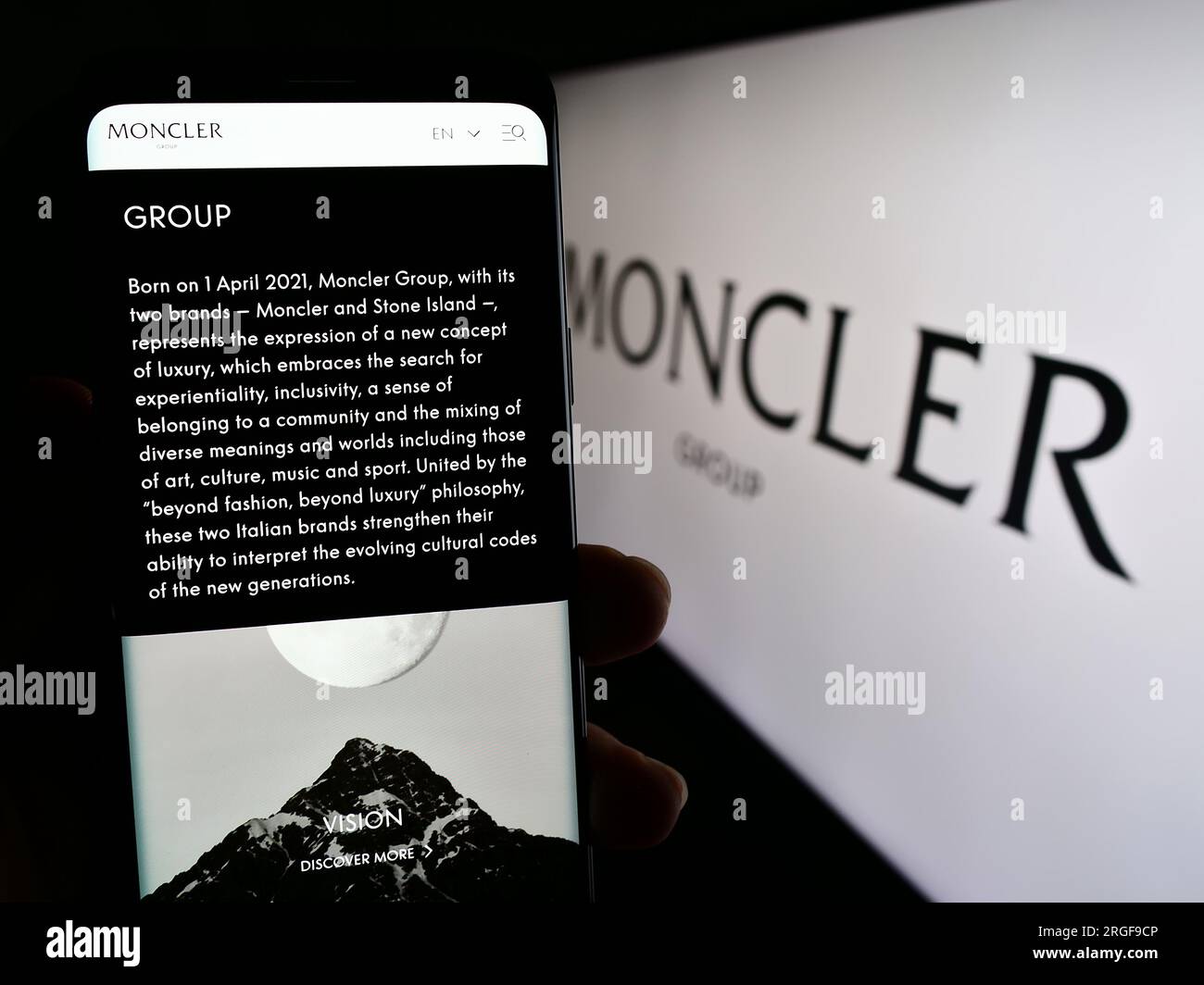 Person holding cellphone with web page of Italian fashion company ...