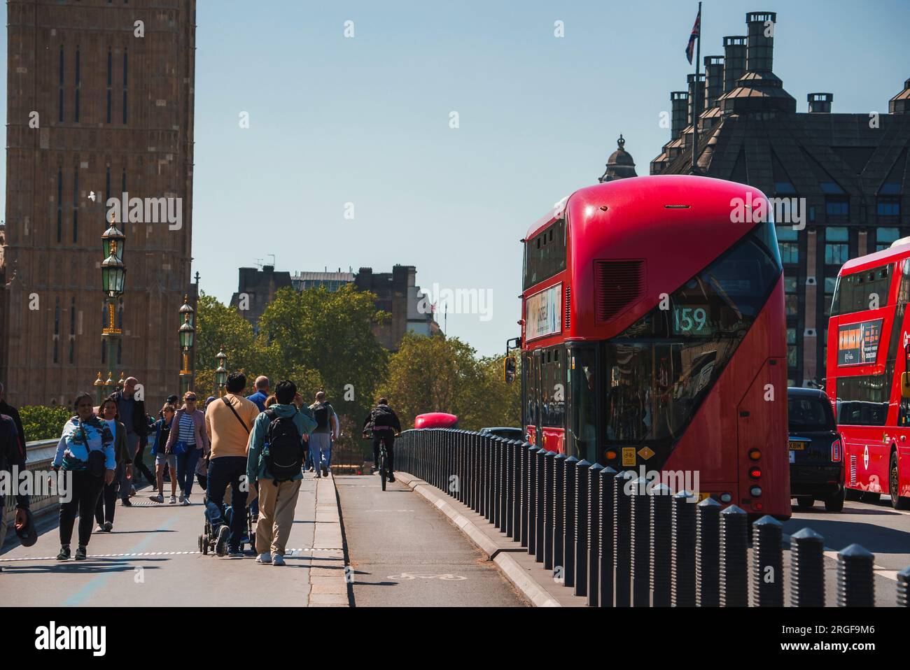 People walking on sidewalk and doubledecker buses moving on road in ...
