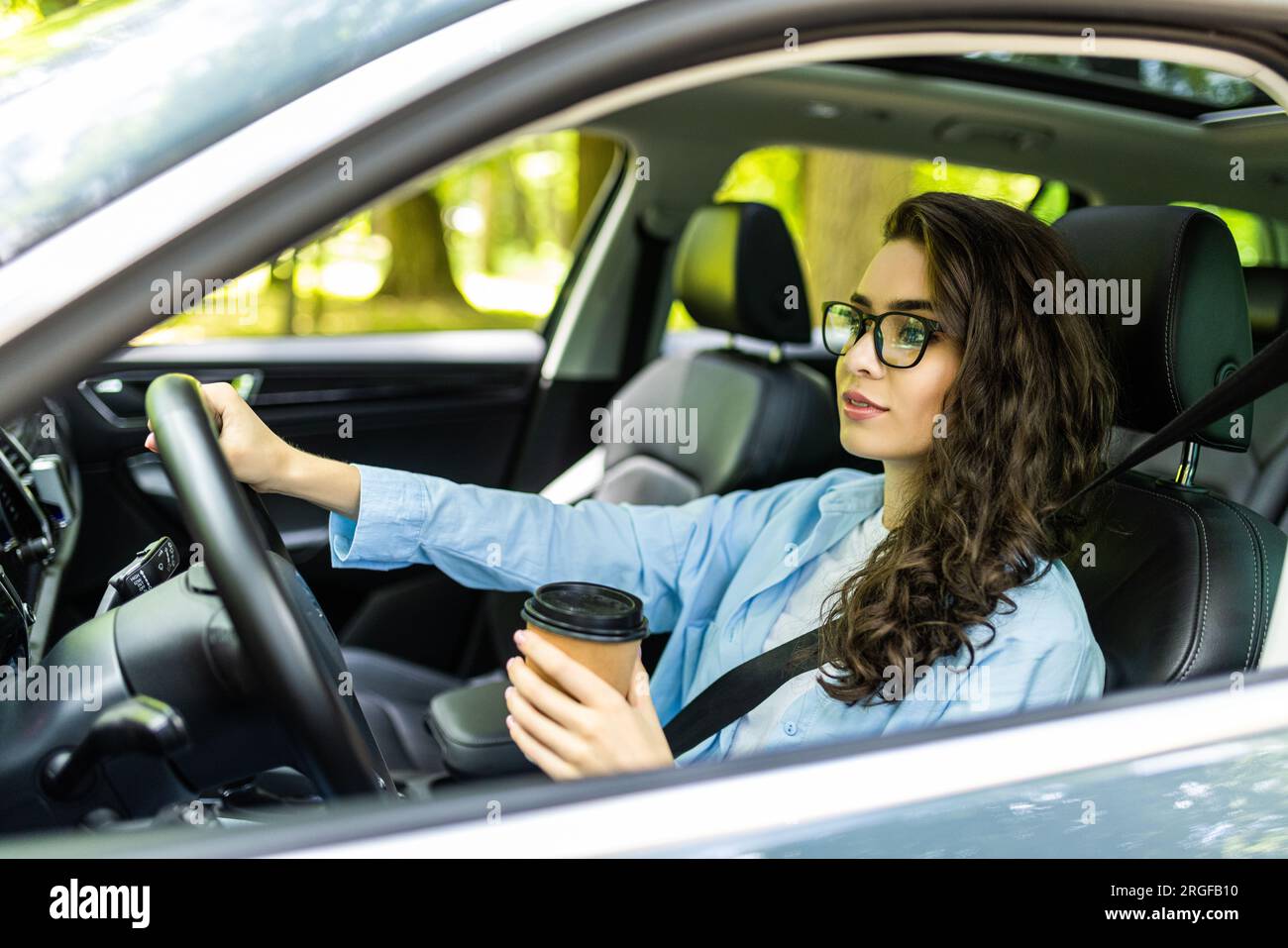 Happy attractive woman driving a car Stock Photo - Alamy