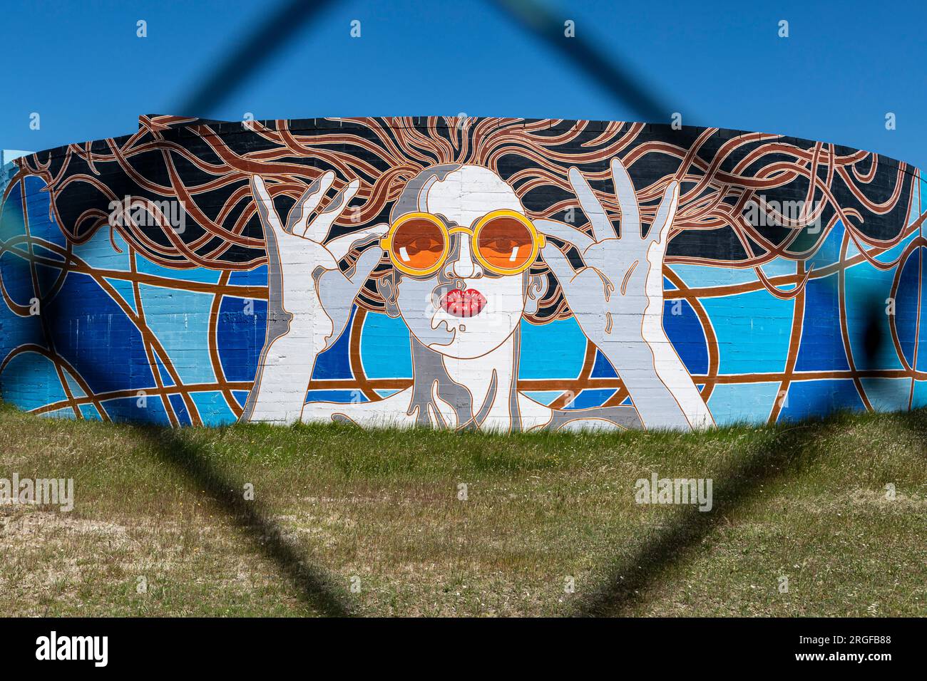 Street art of a white face with bright red lips shot through a ...
