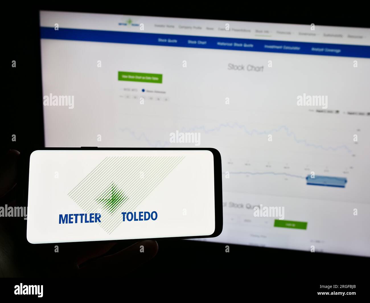 Person holding mobile phone with logo of company Mettler-Toledo ...