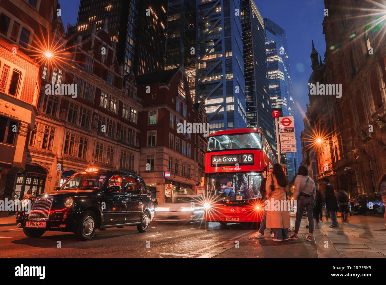 Red bus on stop at the road with city buildings in the background at ...