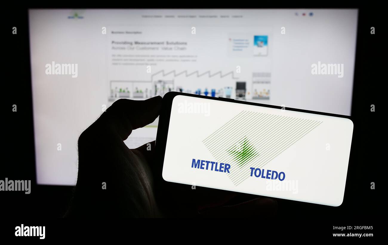 Person holding cellphone with logo of company Mettler-Toledo ...
