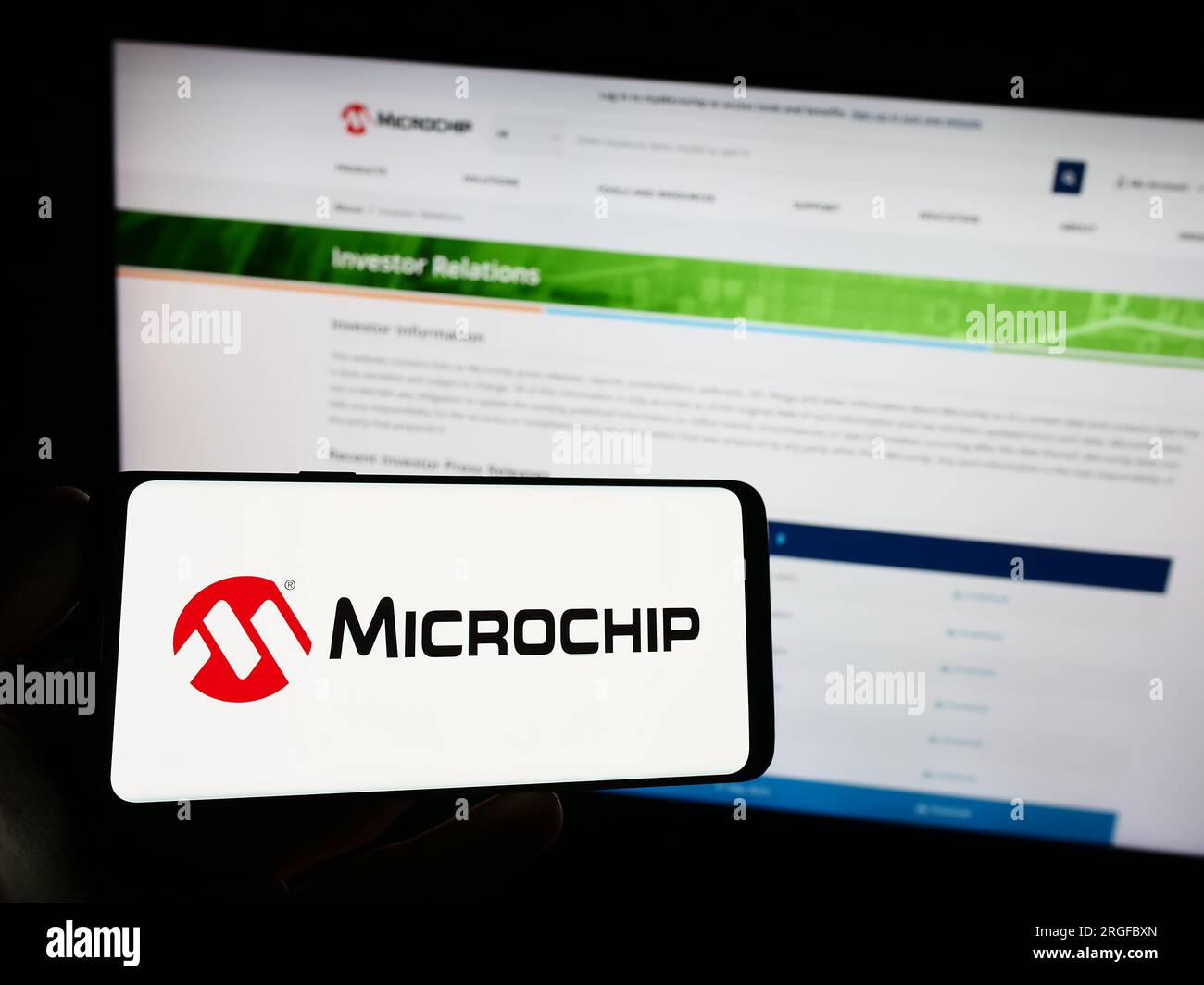 Person holding mobile phone with logo of semiconductor company ...