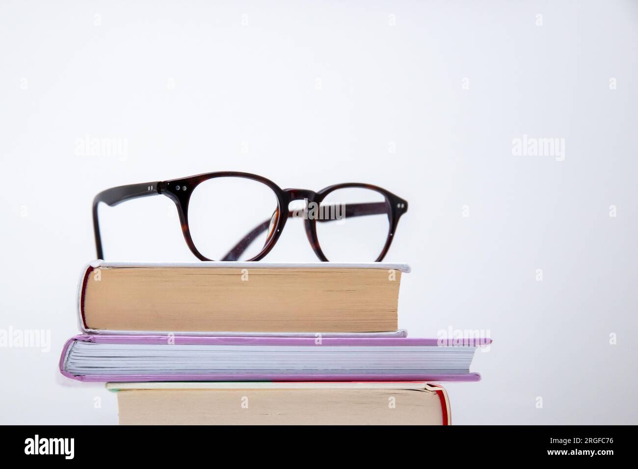 A Stack of books with glasses on top of them Stock Photo - Alamy