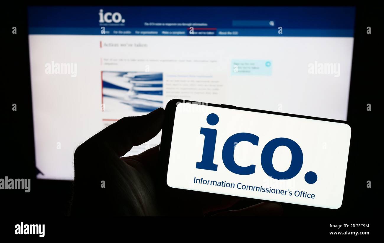 Person holding smartphone with logo of British Information Commissioner's Office (ICO) on screen ...