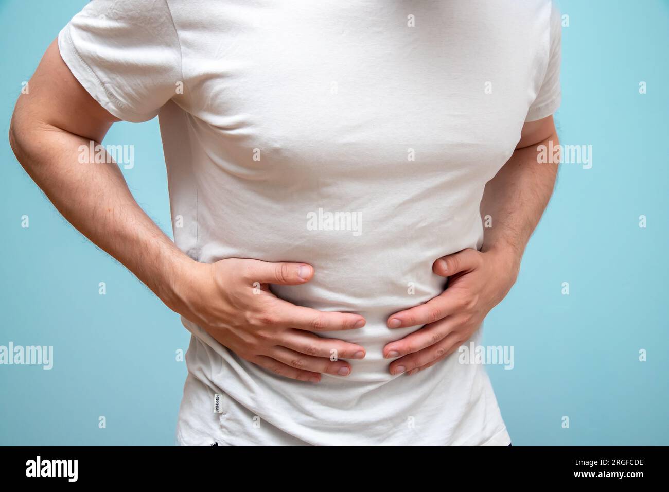 Man holding his stomack out of pain Stock Photo - Alamy