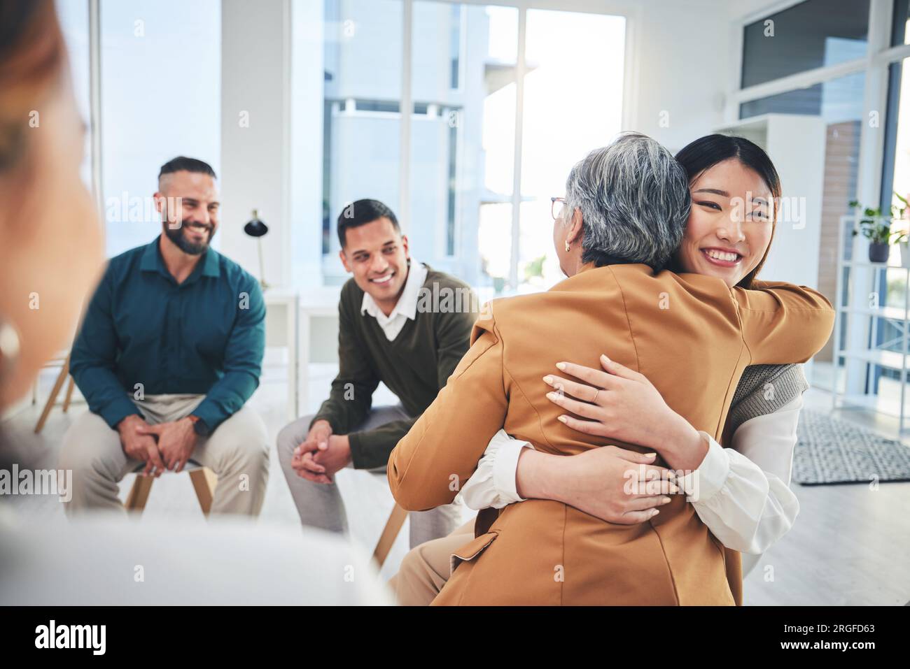 Business people, women and hug in group therapy with care, love and ...