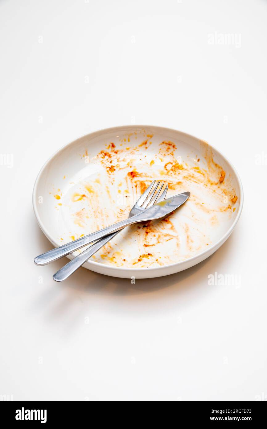 A Dirty plate with fork and knife Stock Photo - Alamy