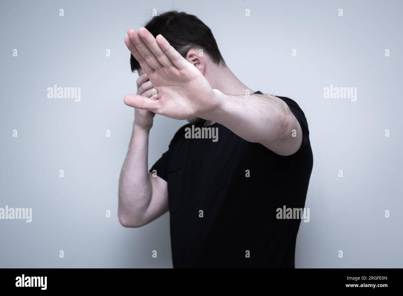 A man covering his face with his arm Stock Photo - Alamy