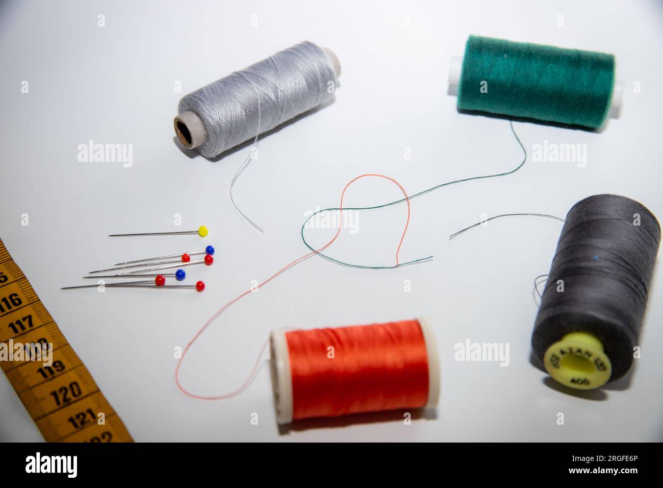 sewing thread forming a shape of heart with some other sewing equipment ...