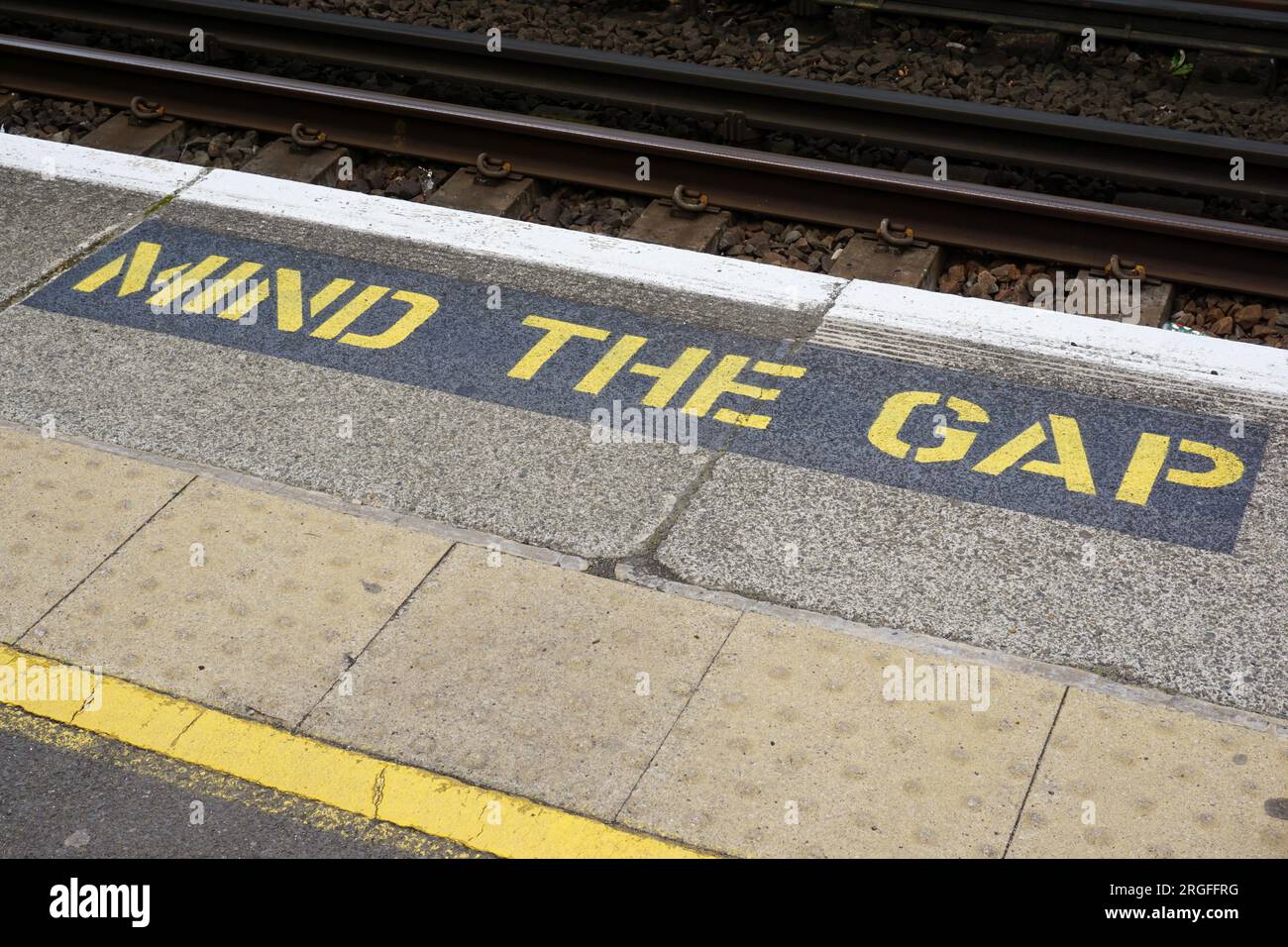 Mind the gap warning message on train station platform edge. Rail ...