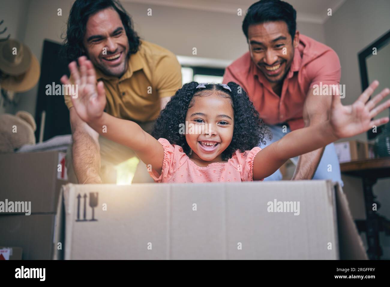 Family home, girl and box with dad, push and gay parents with games ...