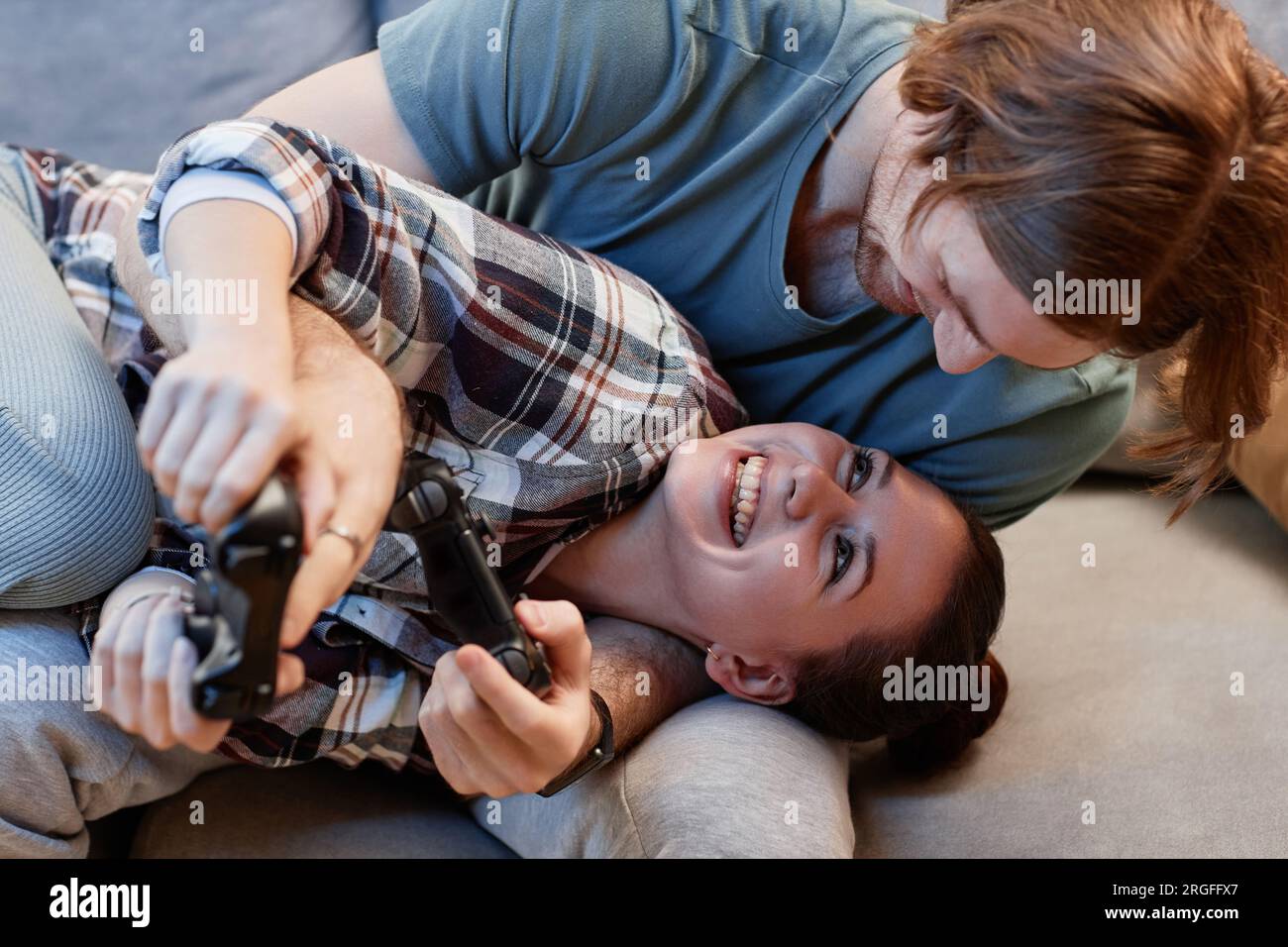 Close up of playful young couple playing video games together and ...