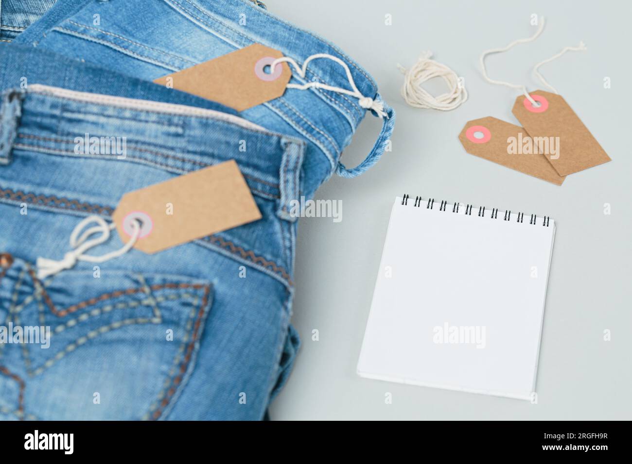 Stack of blue jeans and empty tags on white background Stock Photo - Alamy