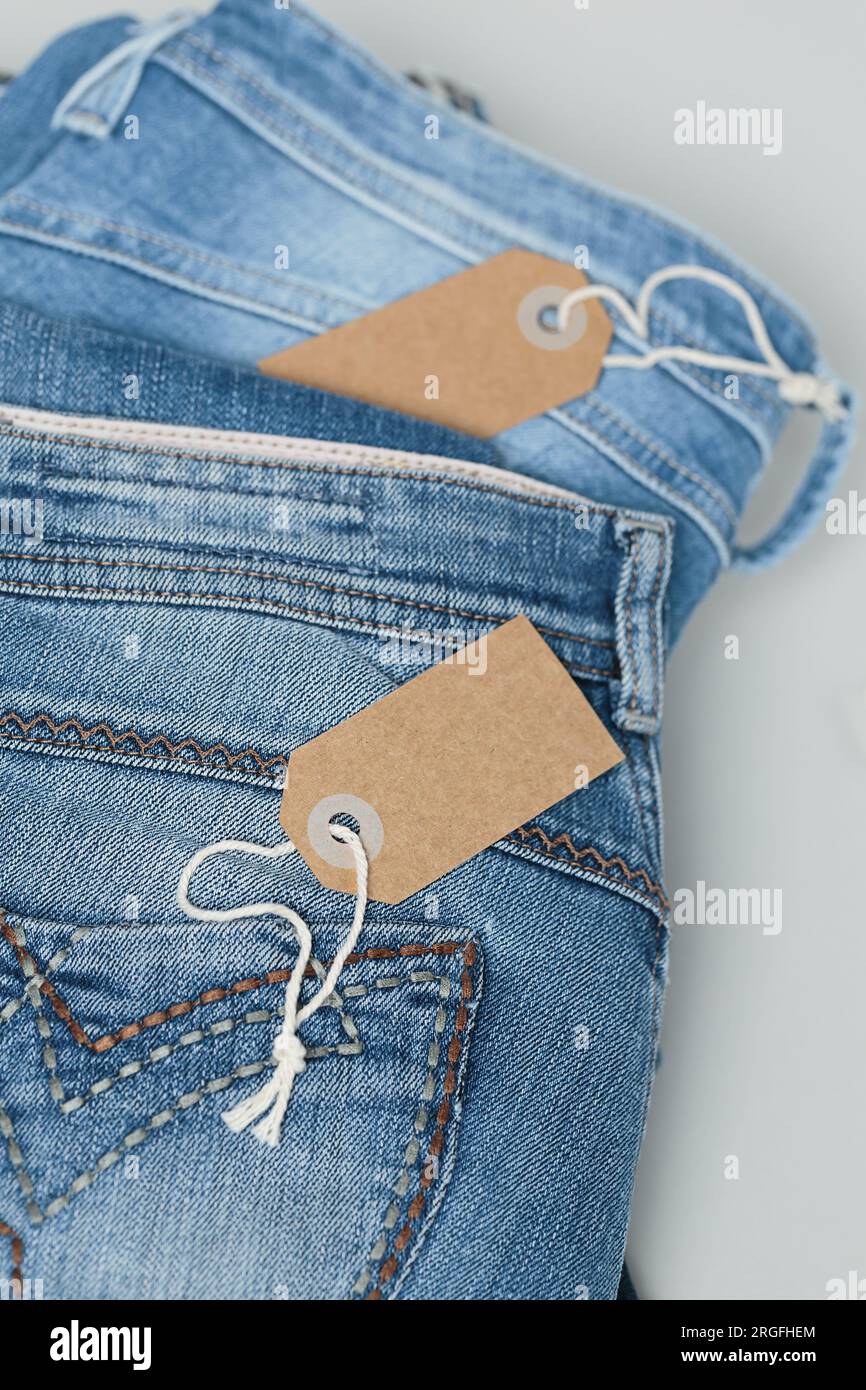 Stack of blue jeans and empty tags on white background Stock Photo - Alamy