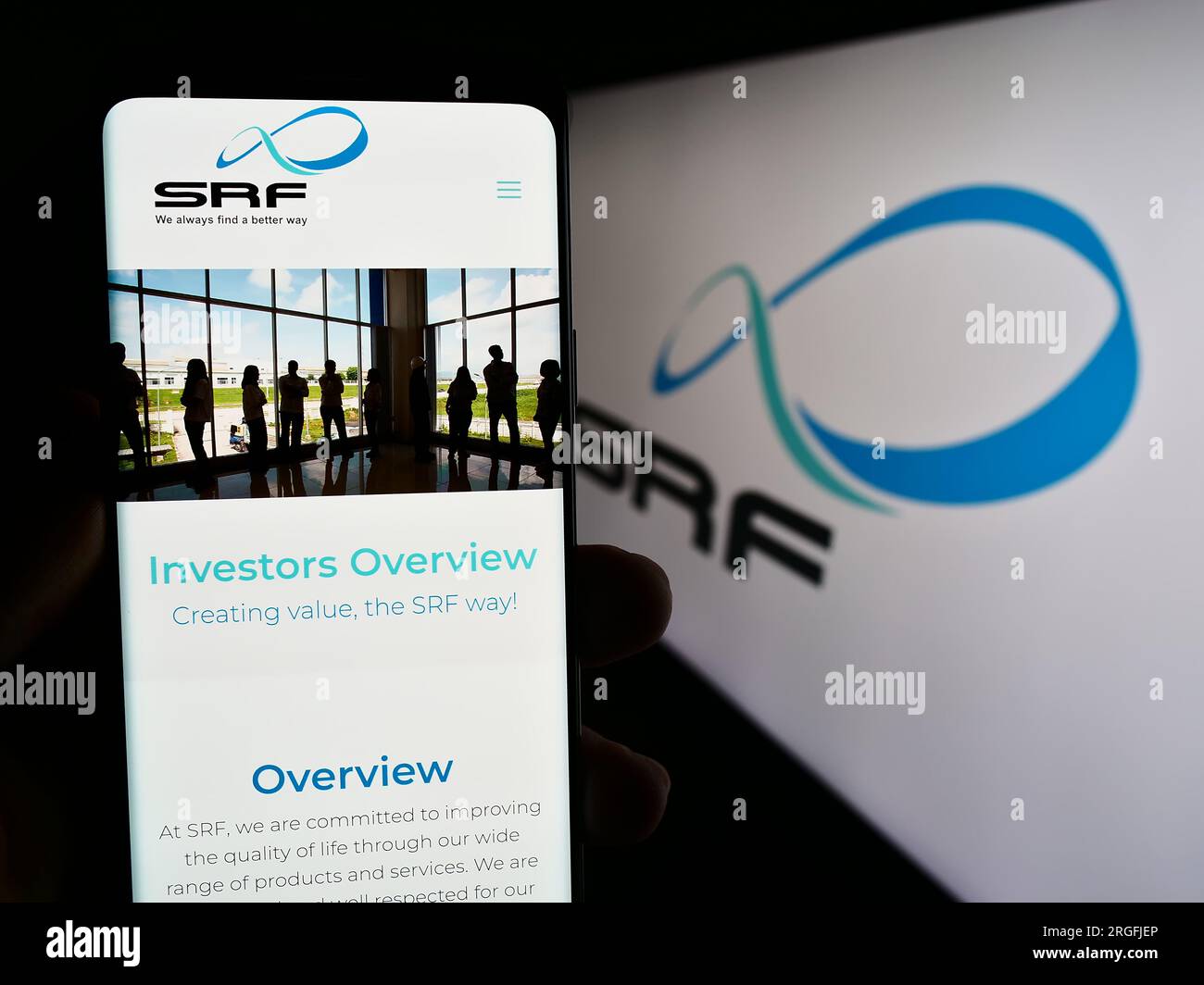 Person holding cellphone with webpage of Indian chemicals company SRF ...