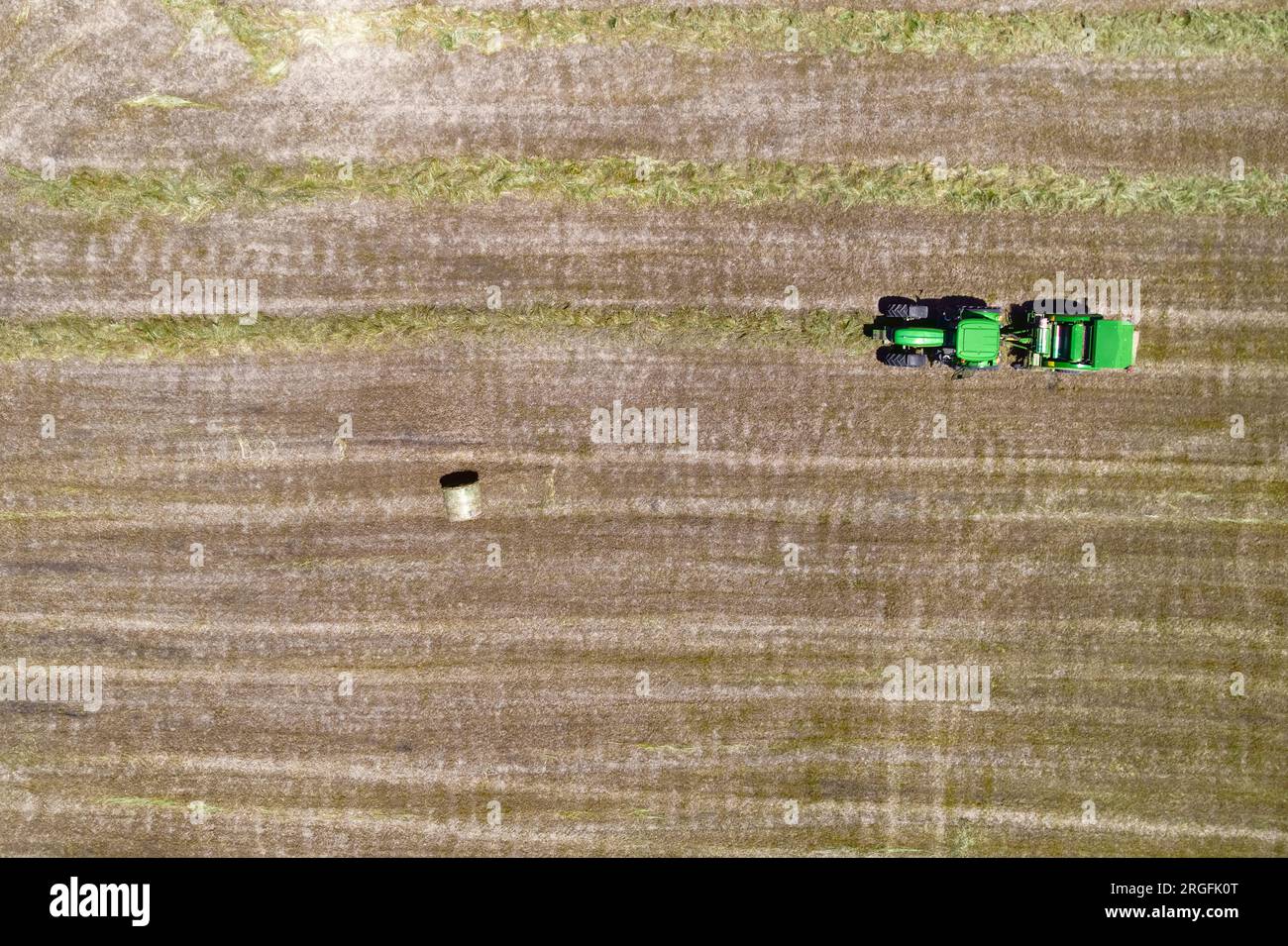 Aerial view of tractor with hay bale. Agricultural machinery. Chamfered ...