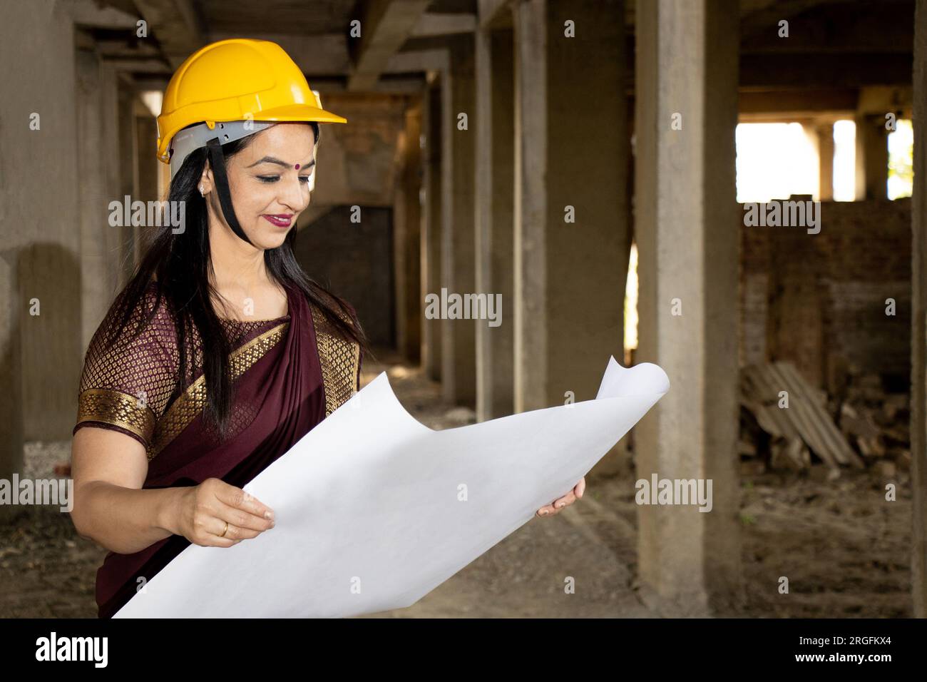 Young beautiful Indian female civil engineer or architect wearing saree ...