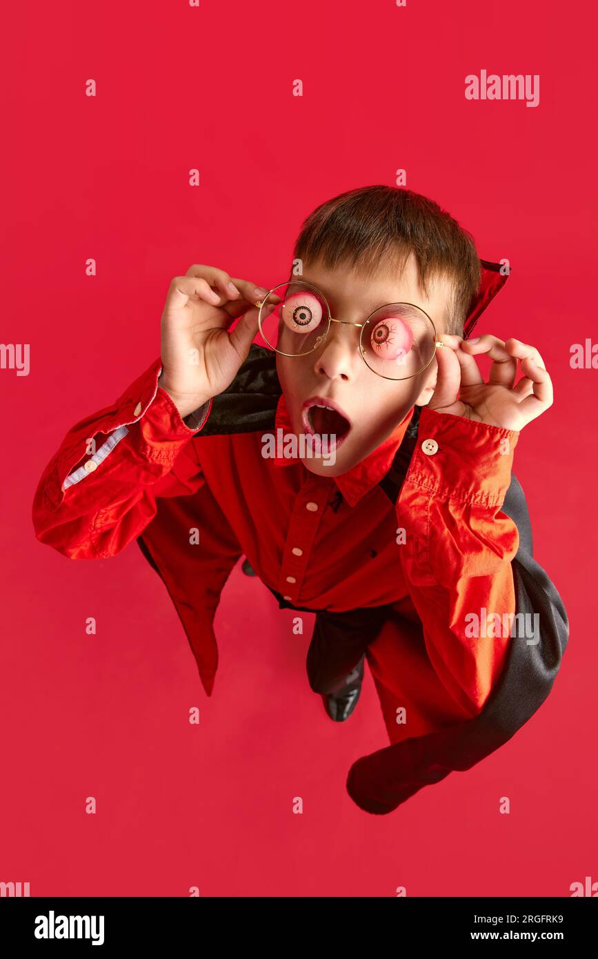 Top view. Little boy, child in costume for halloween party holding fake ...