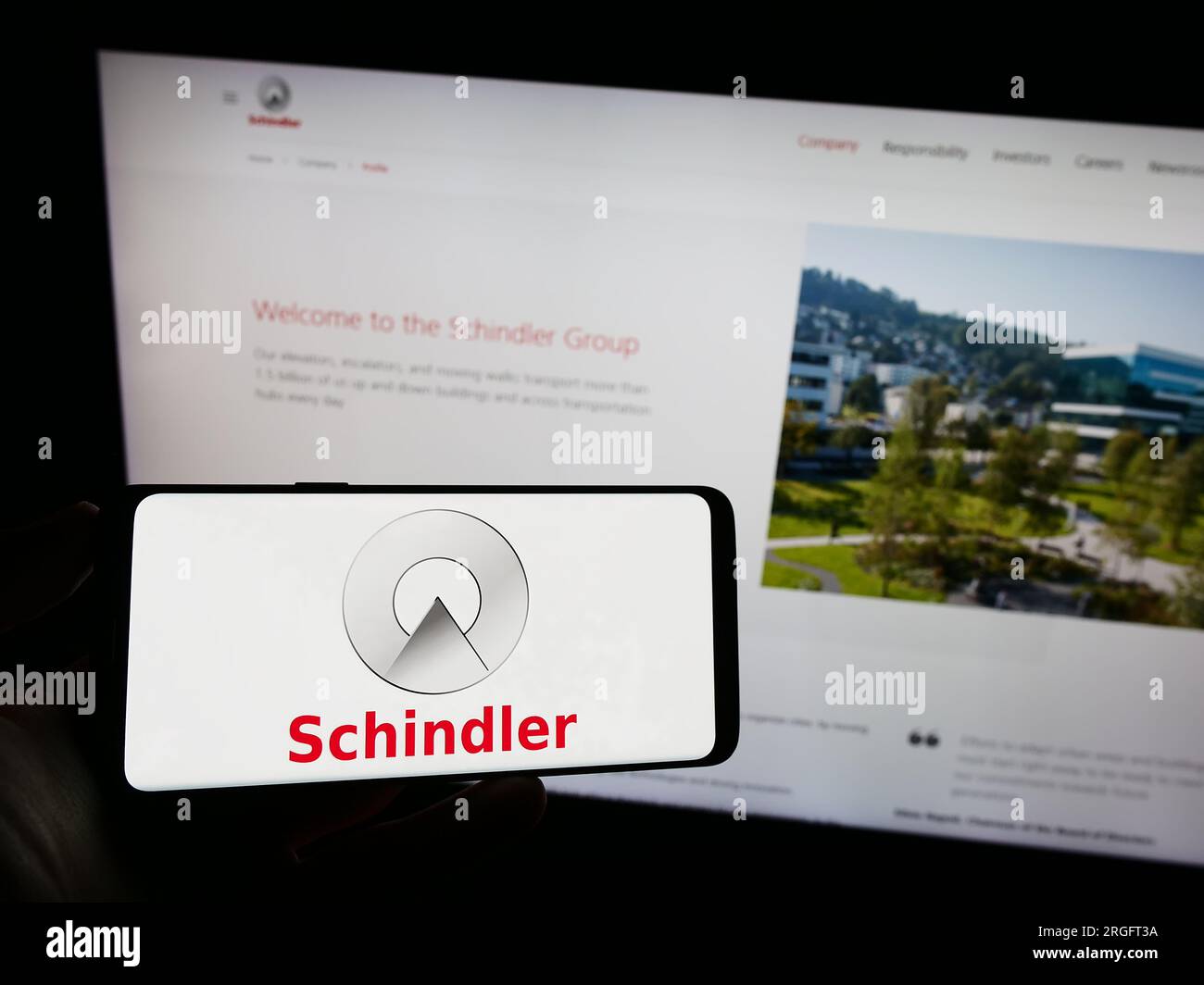 Person holding mobile phone with logo of Swiss elevator company ...