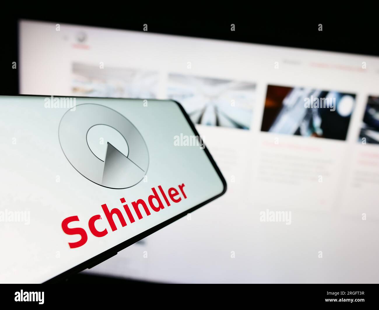 Mobile phone with logo of Swiss elevator company Schindler Group on screen in front of business ...