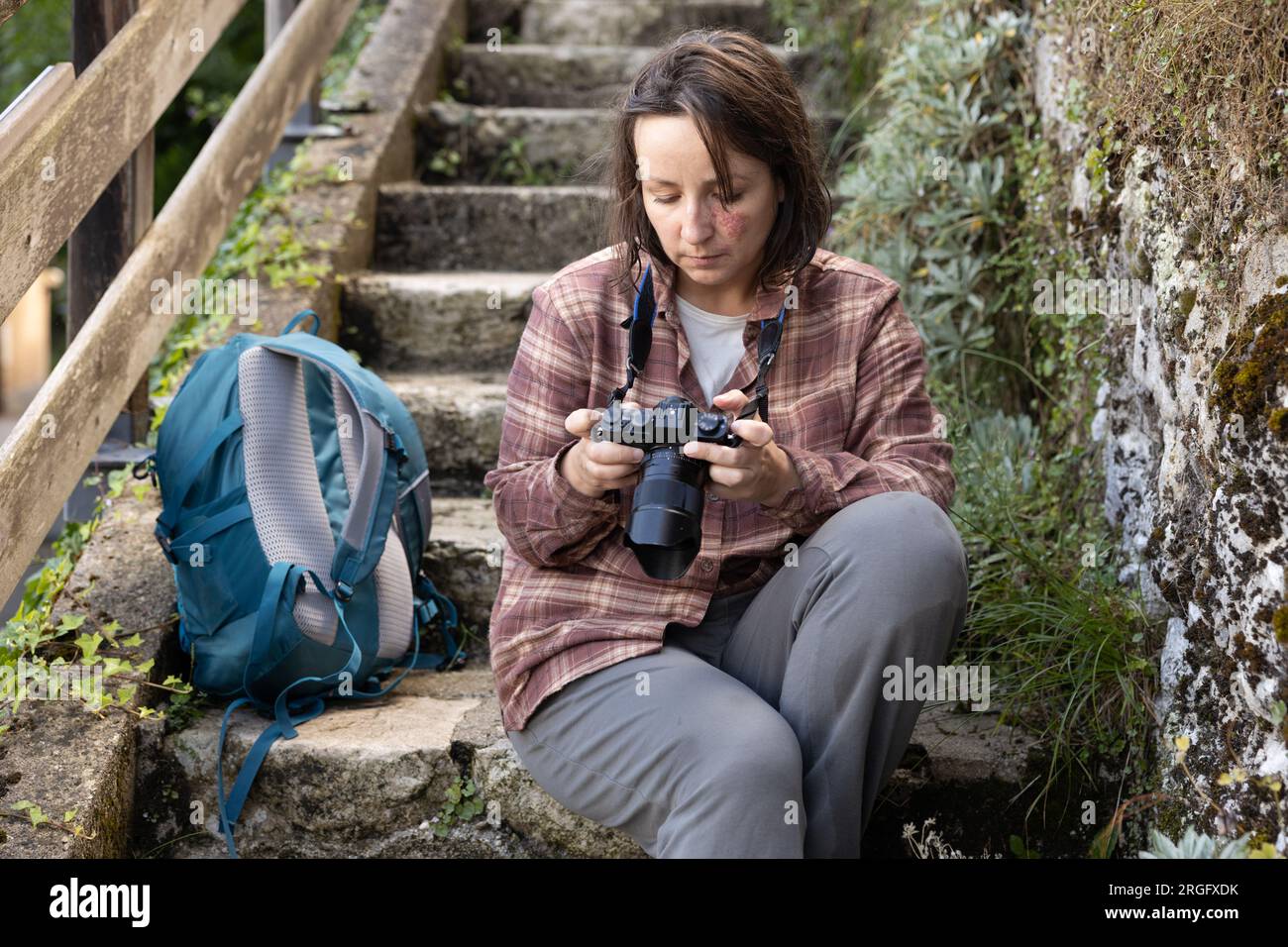 Portrait of a female photographer sitting on a stone staircase and ...