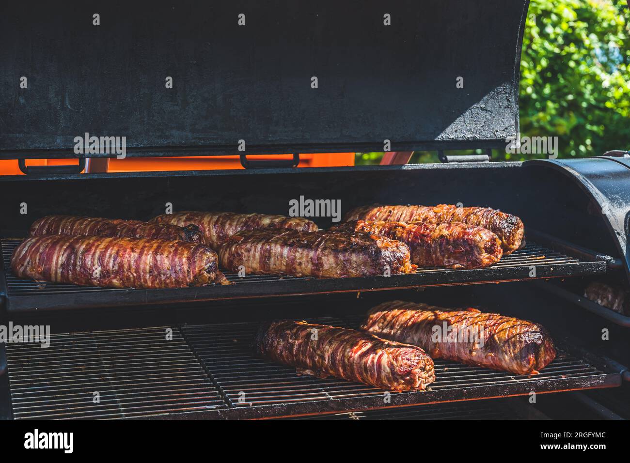 Large barbecue smoker grill at a public festival. Meat and bacon ...