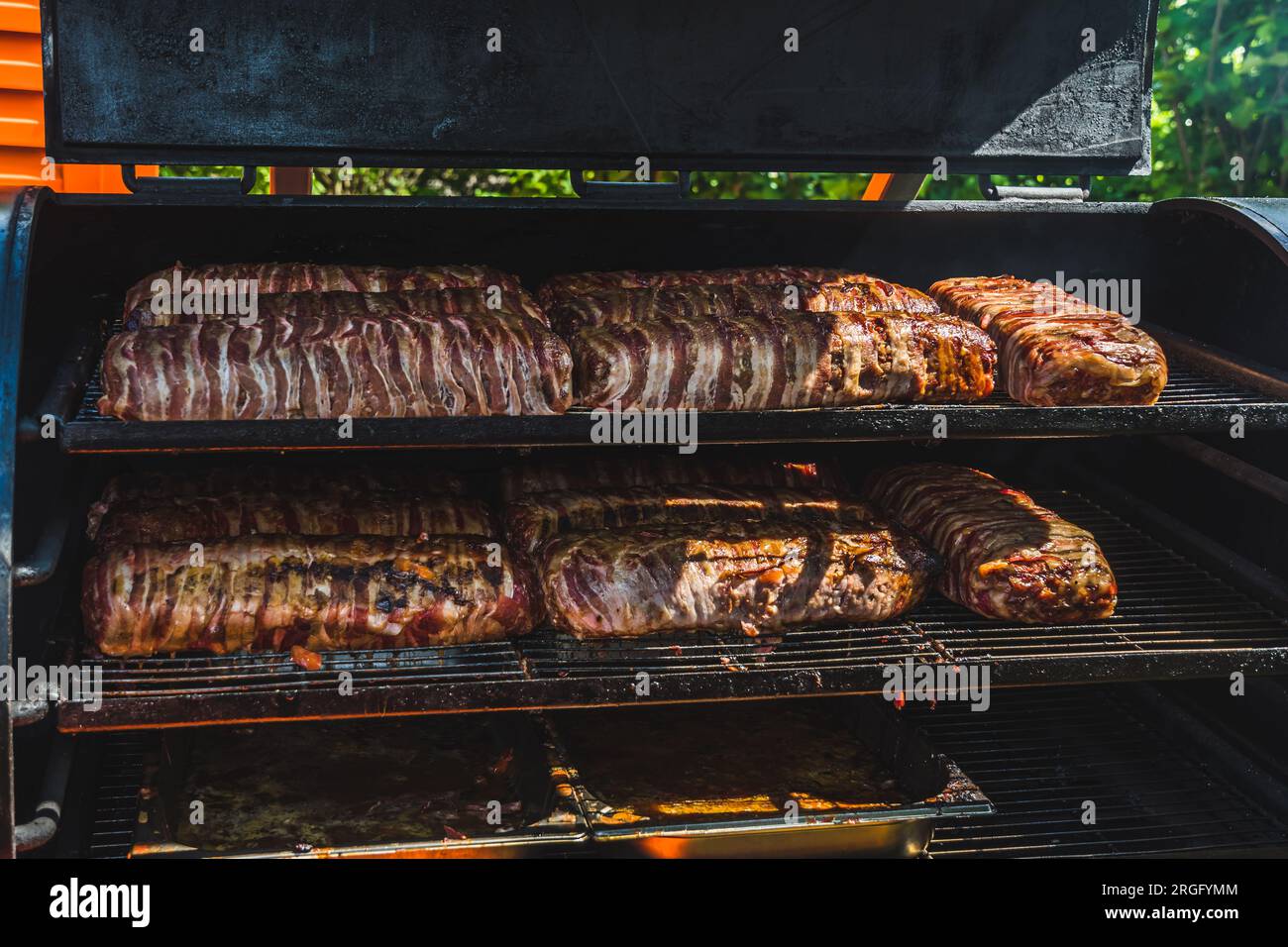 Large barbecue smoker grill at a public festival. Meat and bacon ...