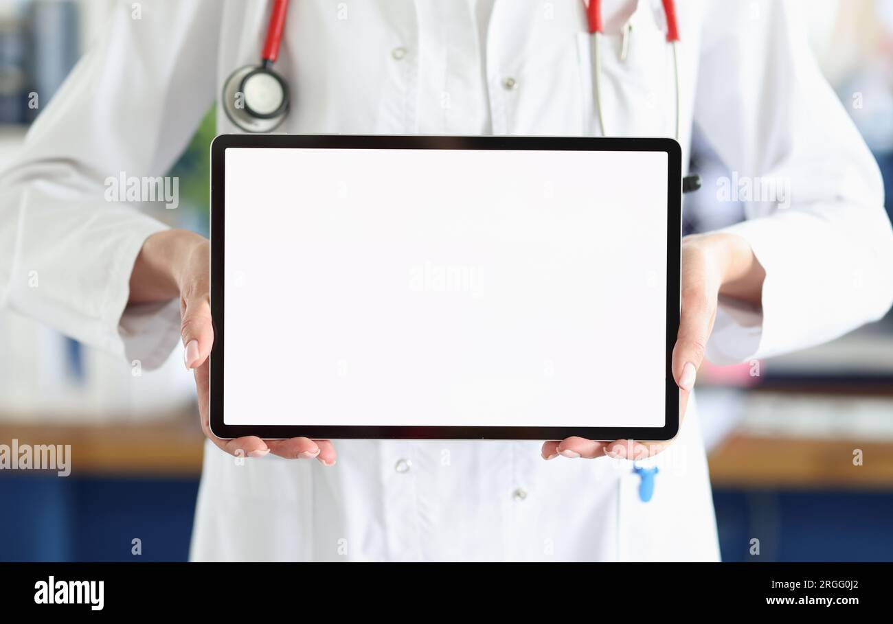 Doctor holds tablet with white screen in medical office Stock Photo - Alamy