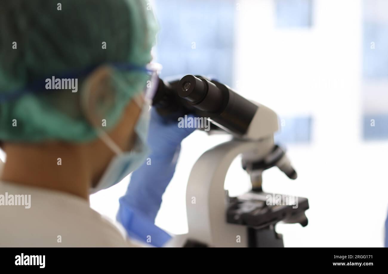 Doctor in glasses looks microscope hi-res stock photography and images ...