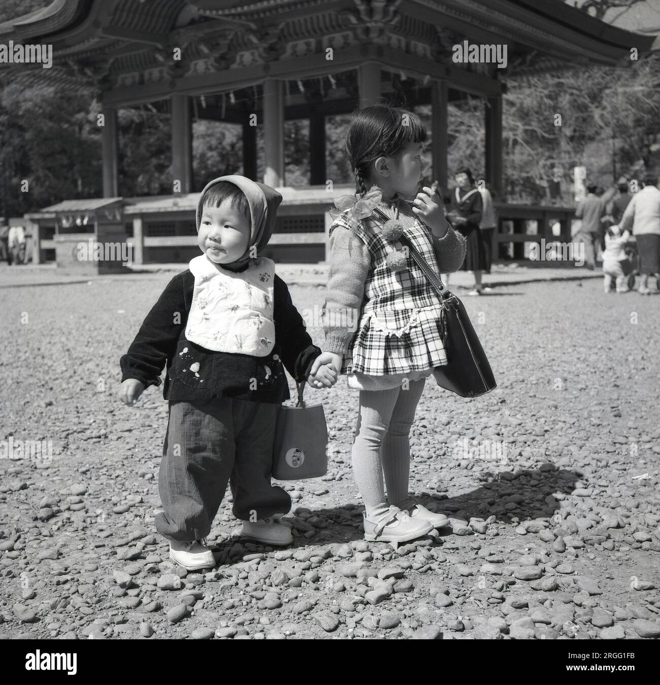 1950s, historica, two small japanese children, sisters holding hands in ...