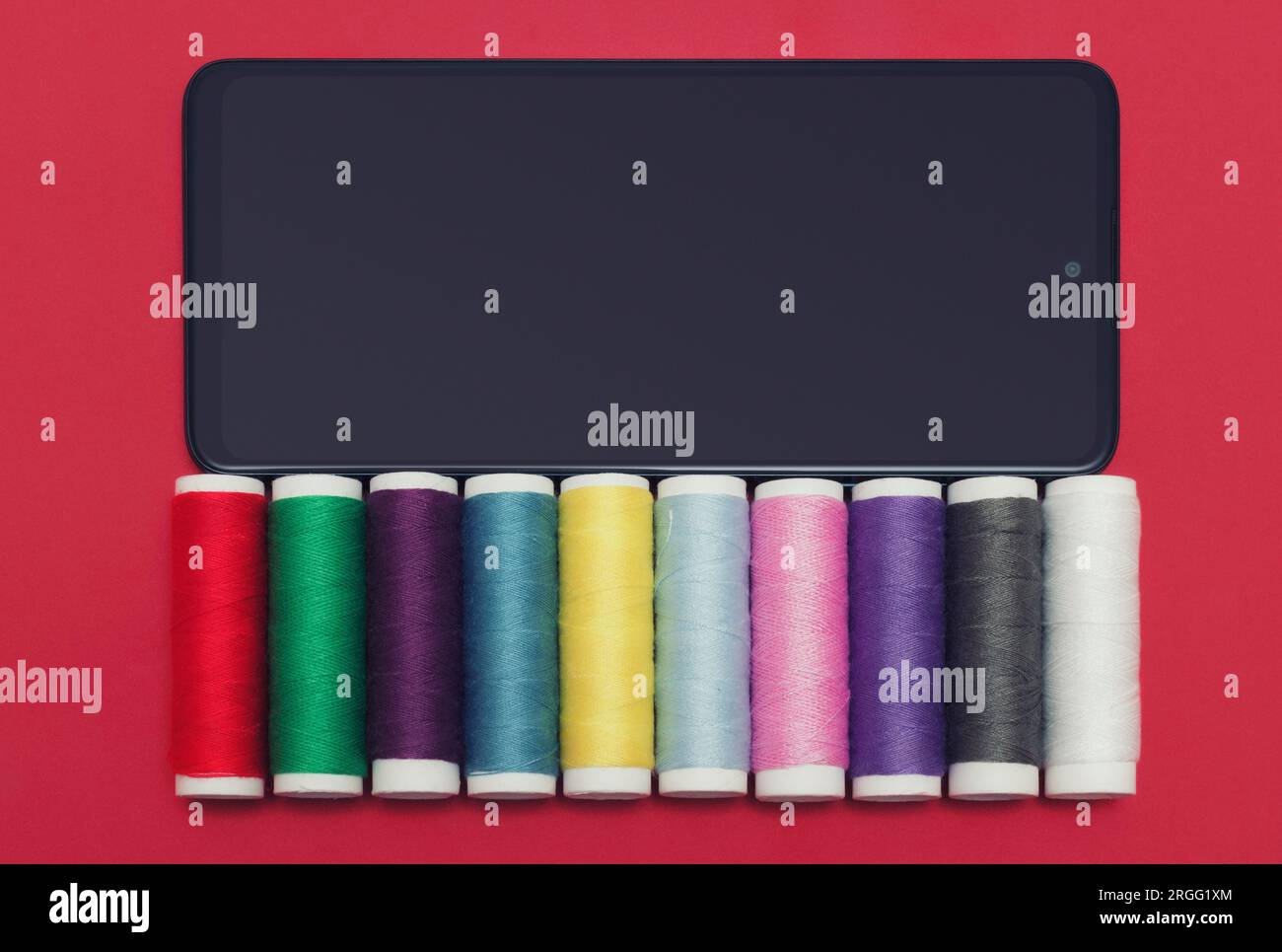 Colorful threads. Smartphone with a set of woolen items. Screen to ...