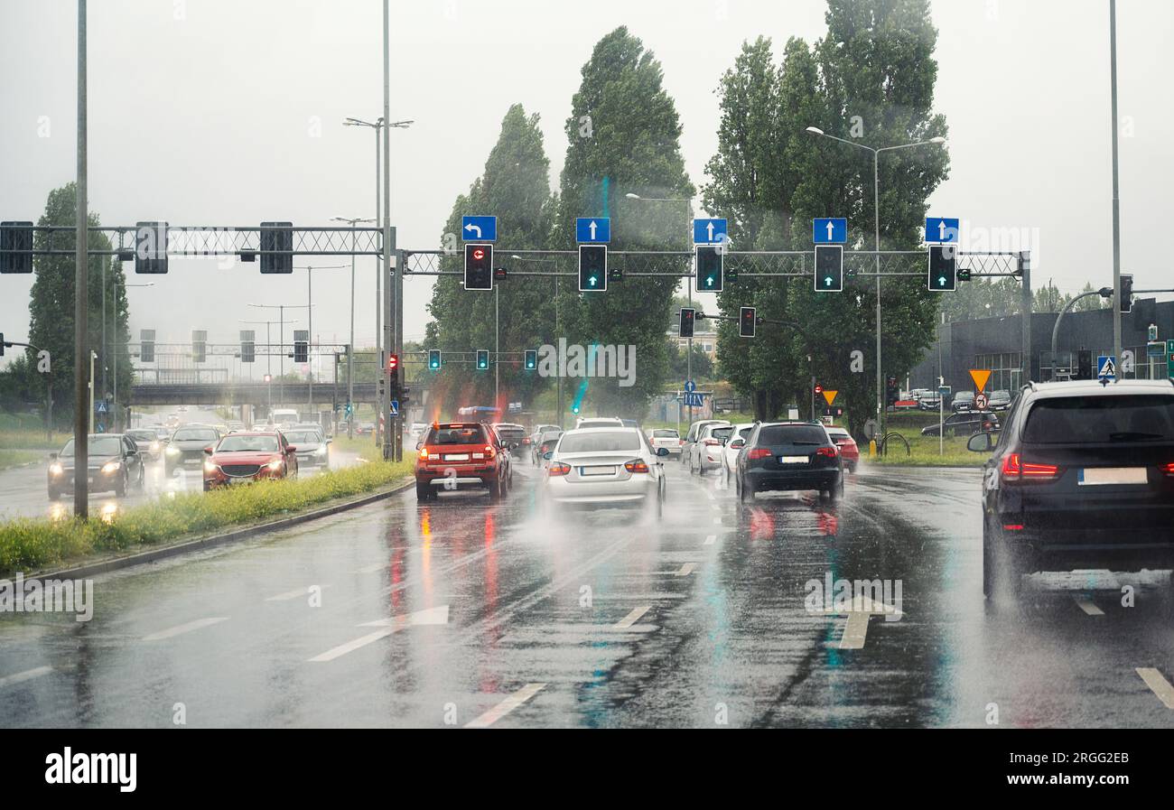 Cars driving on the road, heavy rain, low visibility, slippery street ...