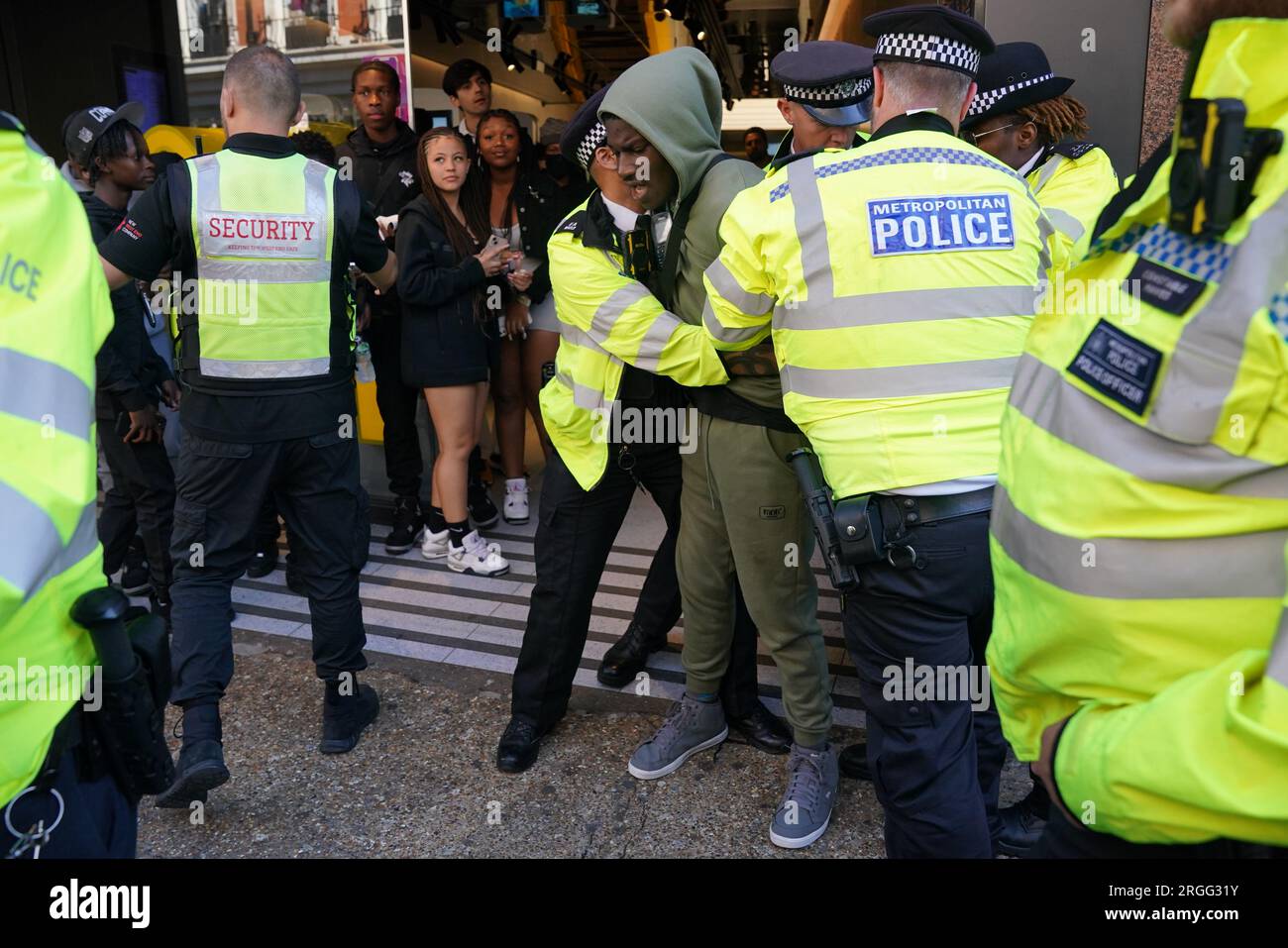 Police officers detain a man outside McDonald's on Oxford Street ...
