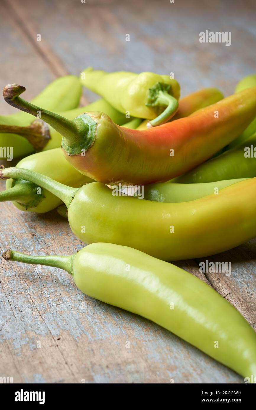 pile of banana peppers on table top, capsicum annuum, popular chili ...